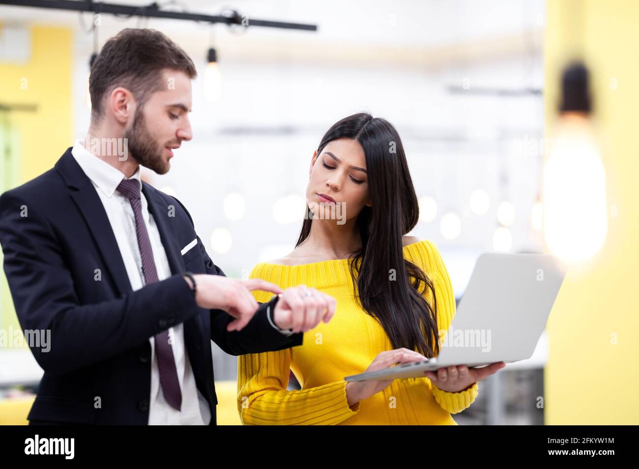 Beautiful Caucasian dark haired girl in yellow posing with businessman ...