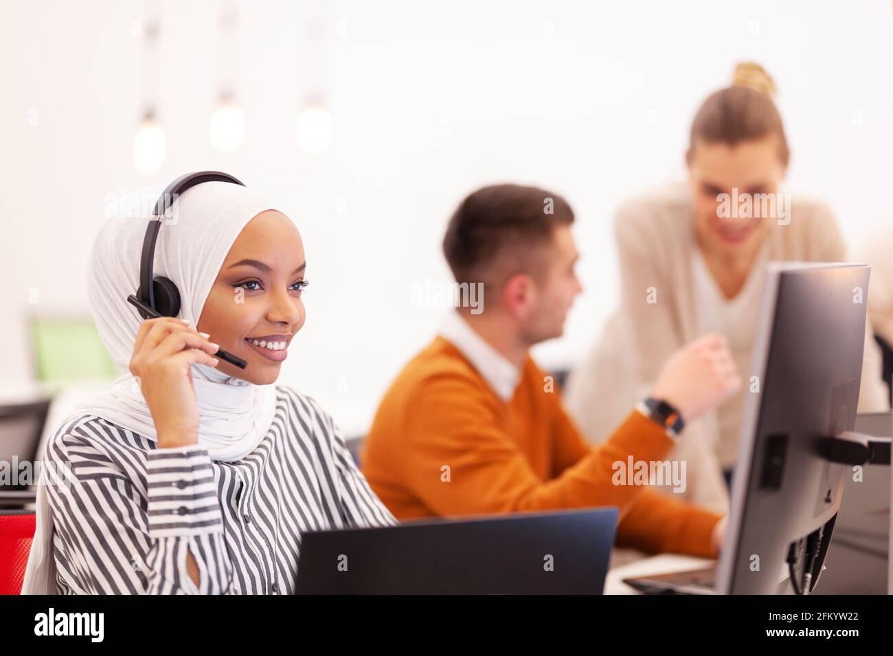 African american muslim girl with hijab and headset in a modern office ...