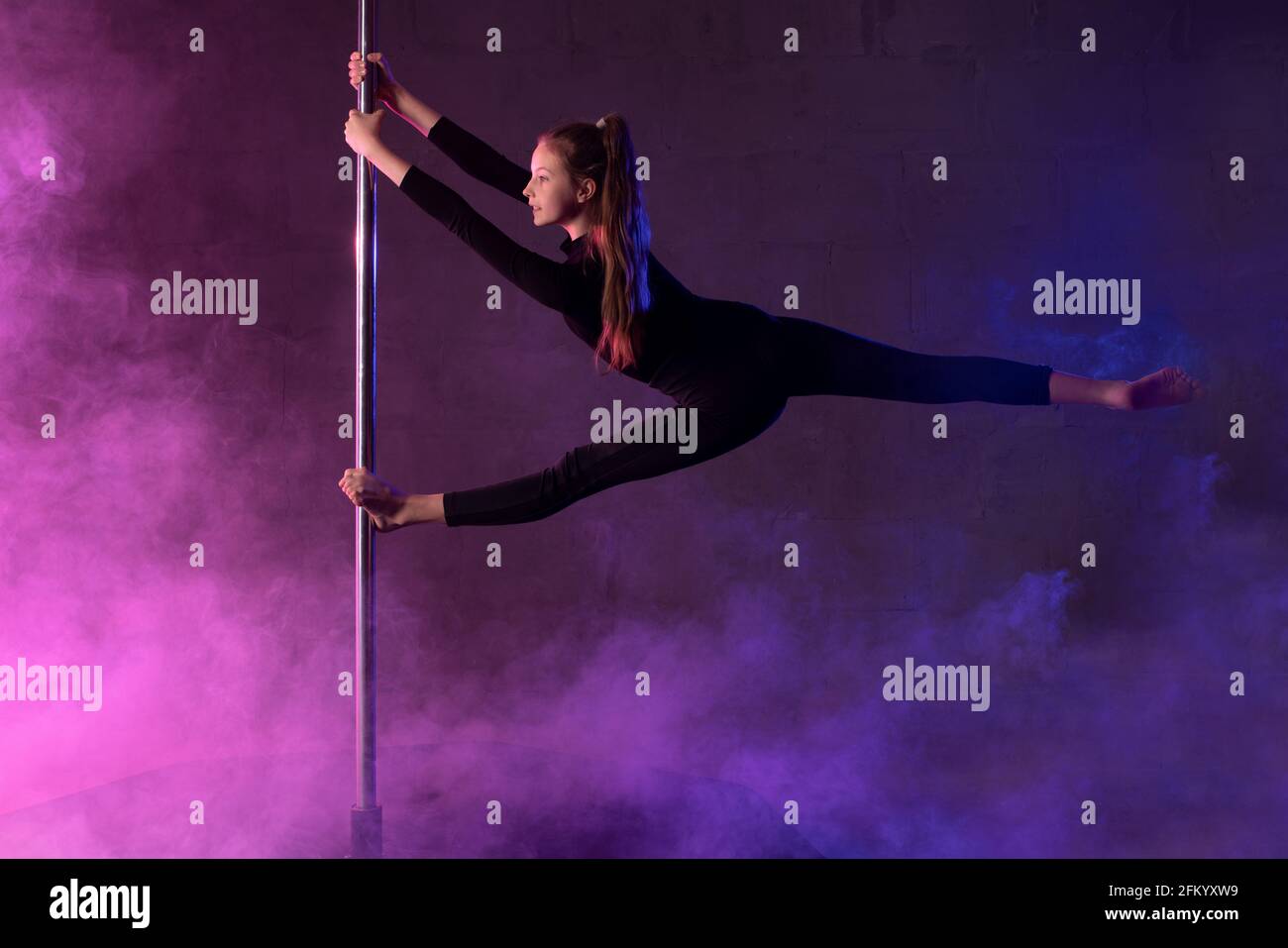 Slim teen pole dancer performing aerial splits Stock Photo - Alamy