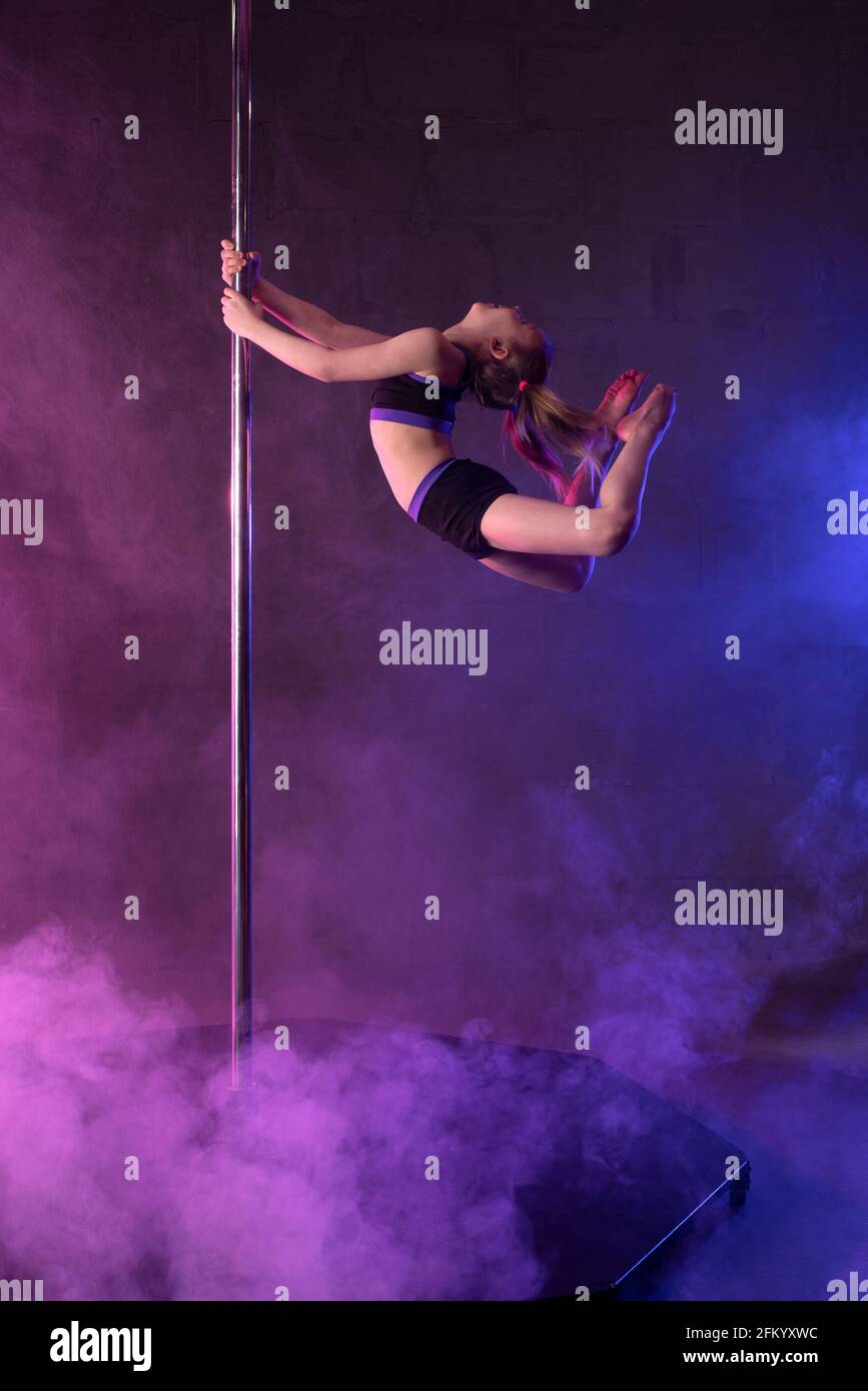 Graceful woman performing pole dance on stage with neon lights Stock ...