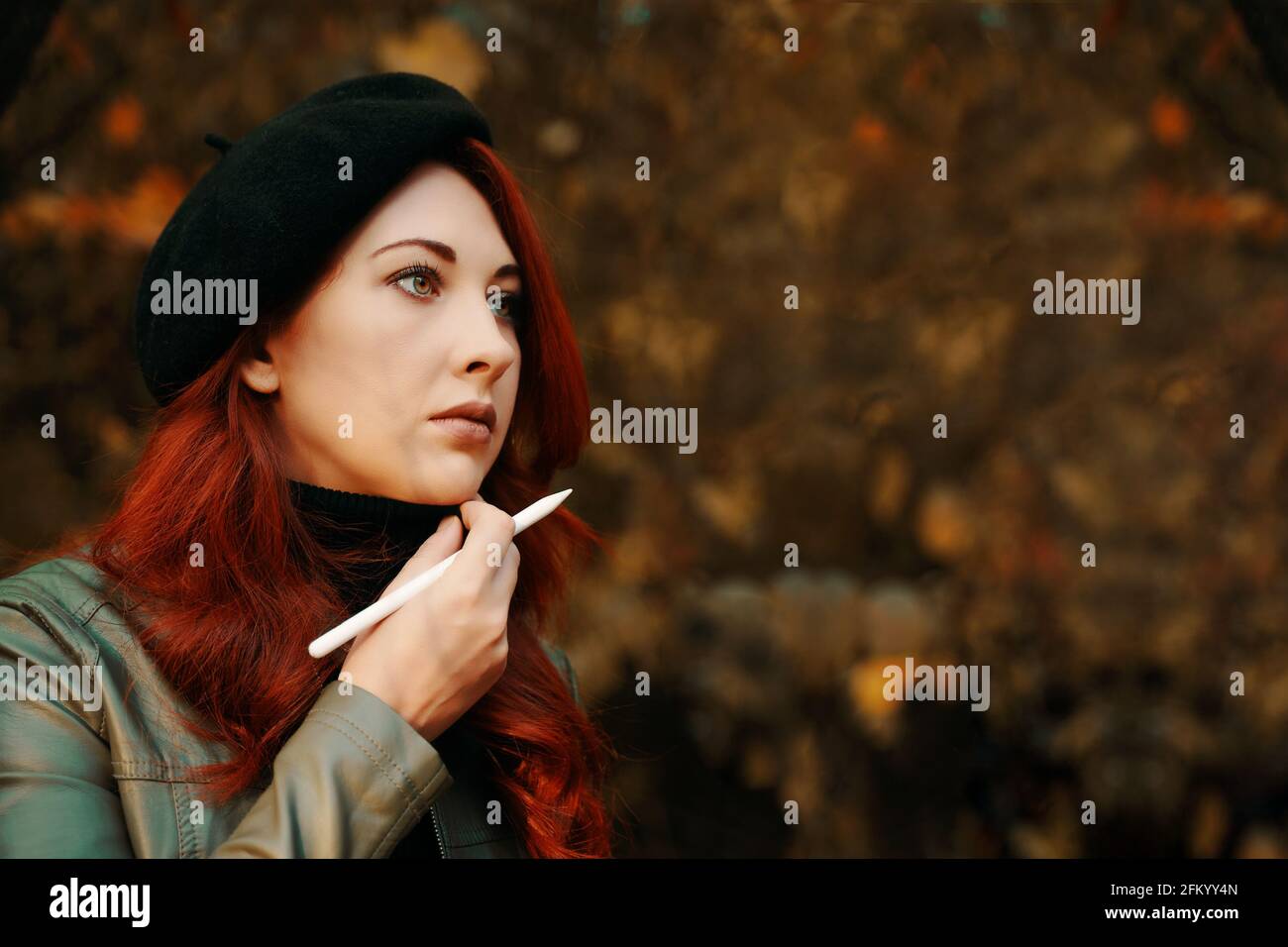 Brooding red-haired woman in the park. Beautiful woman in a beret and ...