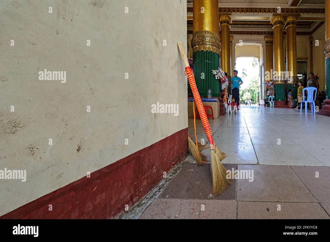 Traditional type broom leaning against a wall inside the Shwedagon ...