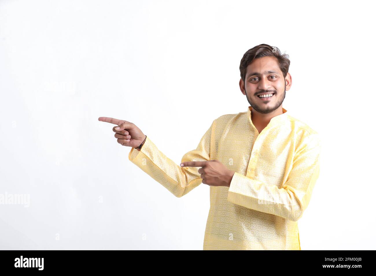 Young indian man showing direction on white background Stock Photo - Alamy