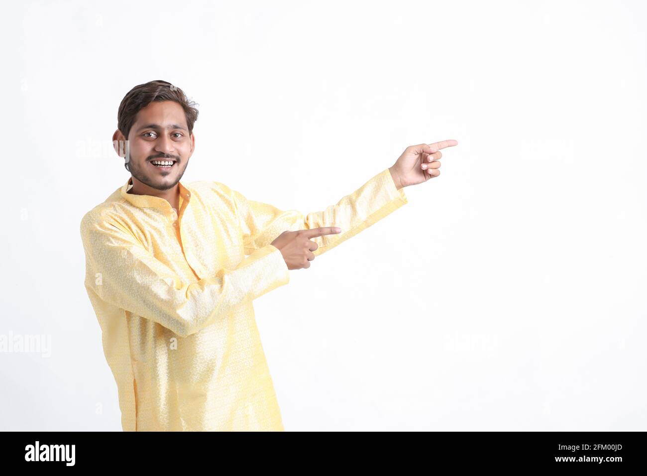 Young indian man showing direction on white background Stock Photo - Alamy