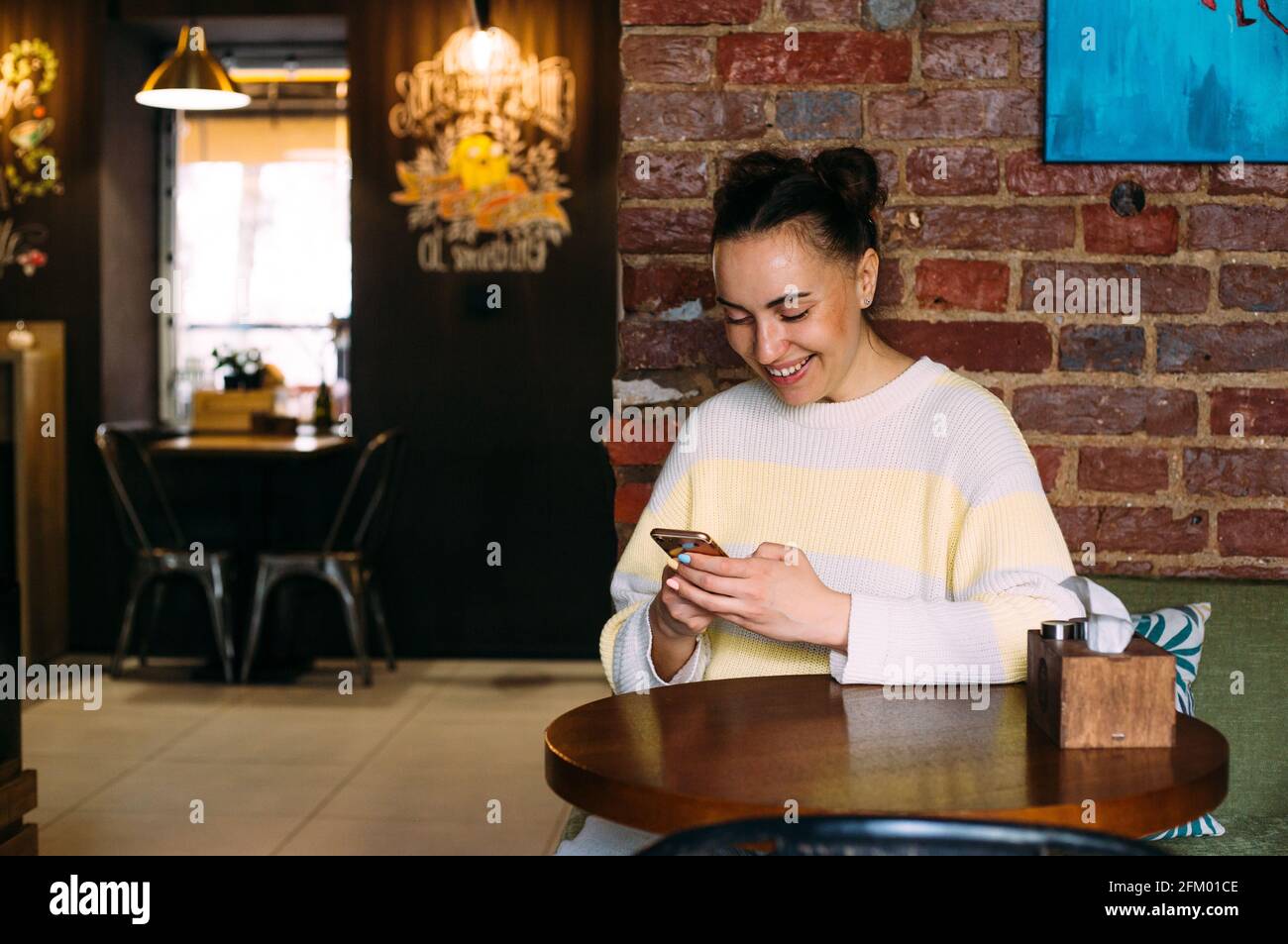 Woman alone smartphone sitting texting hi-res stock photography and ...