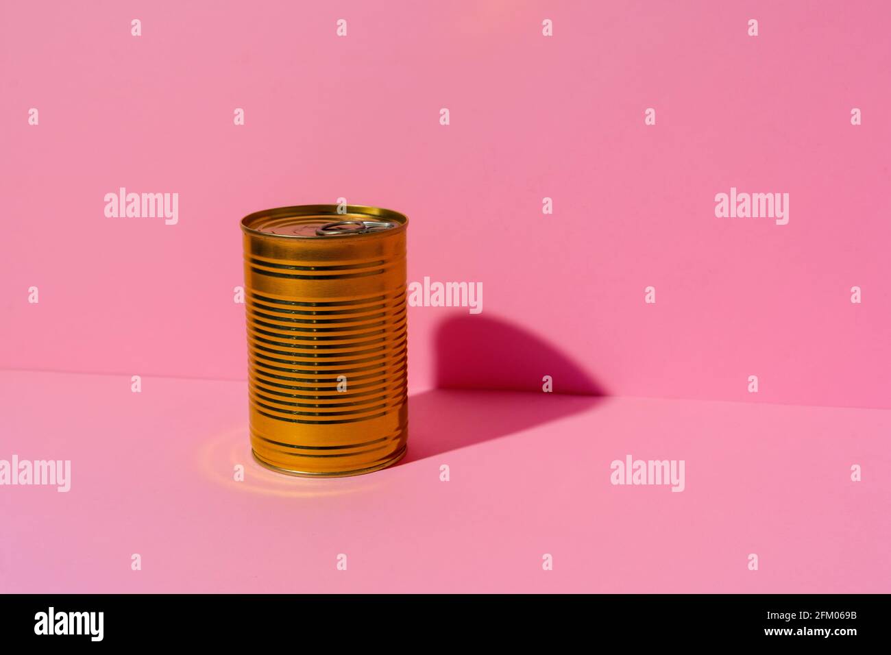 Canned food tin on pink studio background Stock Photo - Alamy