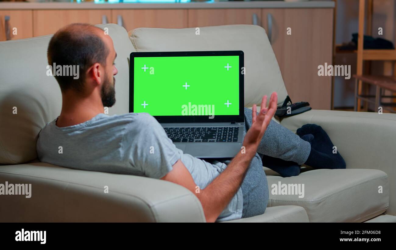 Focused man looking laptop computer with at mock up green screen chroma ...