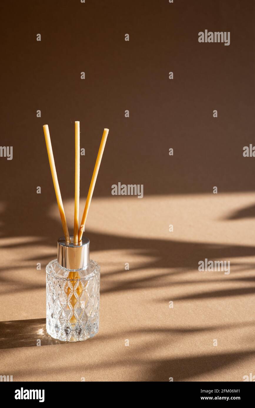 Aromatic reed air freshener on brown background hard shadow ...