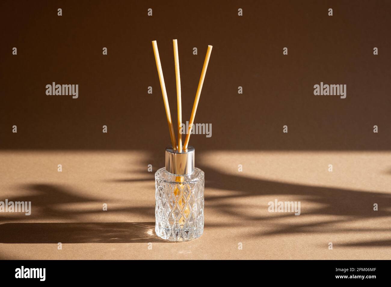 Aromatic reed air freshener on brown background hard shadow ...