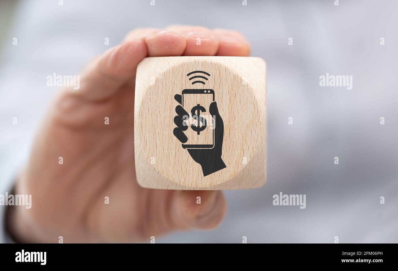 Hand holding a wooden cube with symbol of mobile payment concept Stock ...