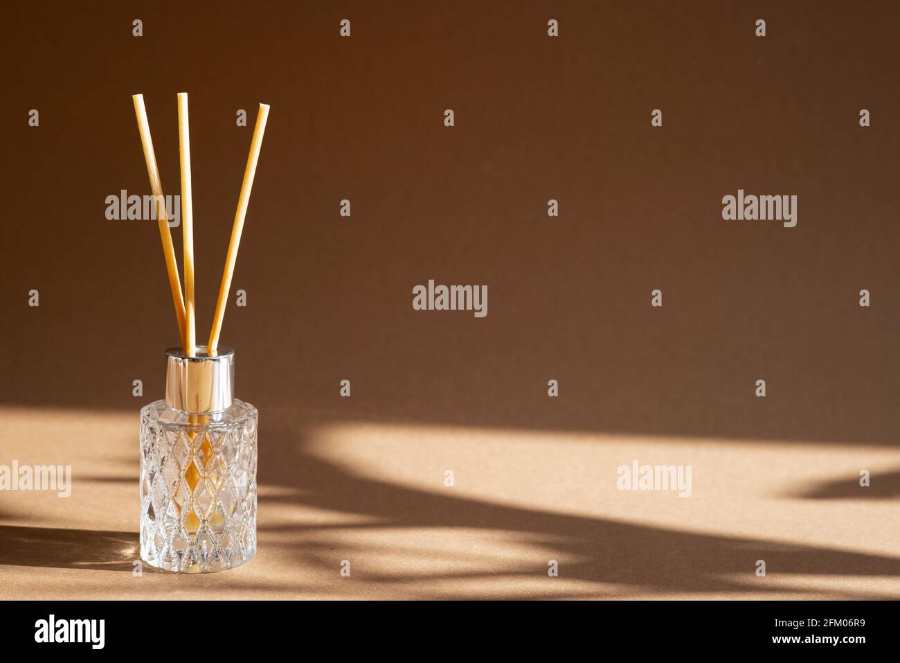 Aromatic reed air freshener on brown background hard shadow ...
