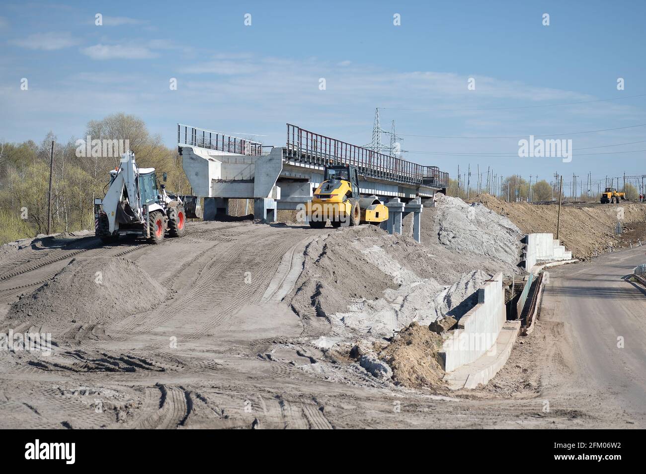 Construction equipment forms an artificial embankment and compresses ...