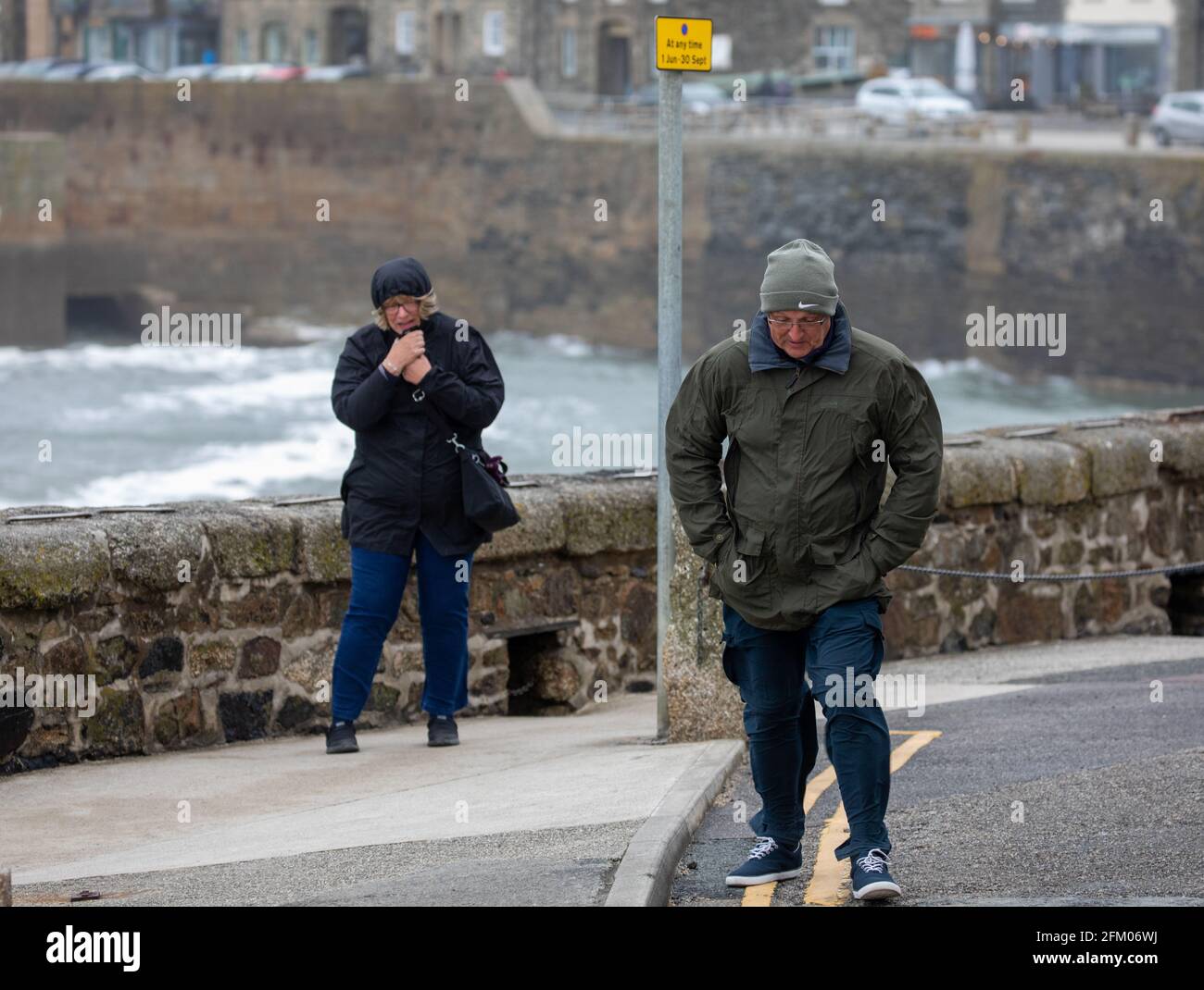 People struggle to walk against the strong winds in Porthleven ...