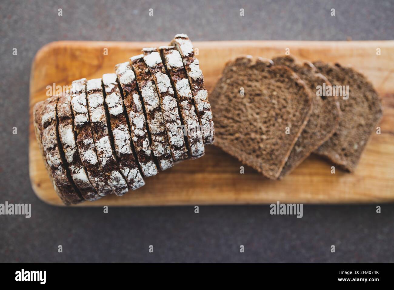 fresh loaf of sliced German rye bread on cutting board, concept of ...