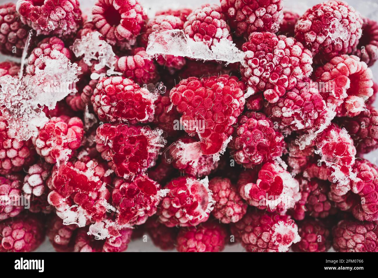 frozen raspberries close-up with visible ice, healthy plant-based food ...
