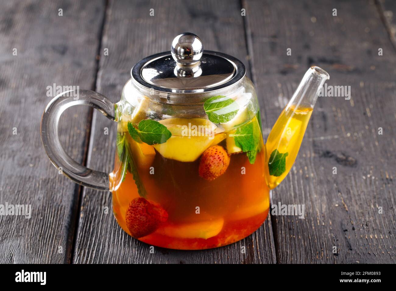 Teapot of herbal fruit tea with strawberry Stock Photo - Alamy