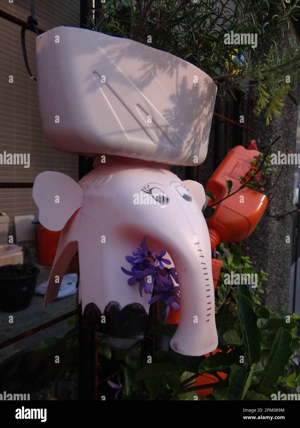 Vertical shot of plants on elephant design plastic bottle container in ...