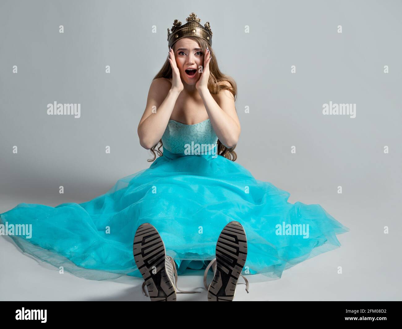 Beautiful queen is in shock, a young beautiful blonde in a lush blue ...