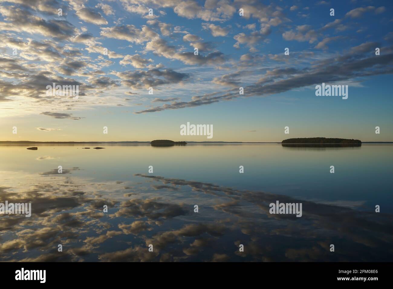 Clouds reflecting on the water in evening Stock Photo - Alamy