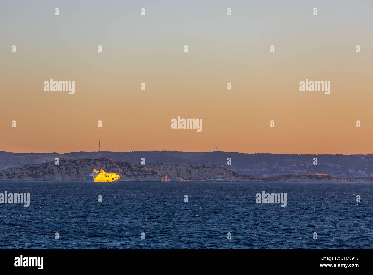 Ferry in the distance lit by the rising sun hi-res stock photography ...