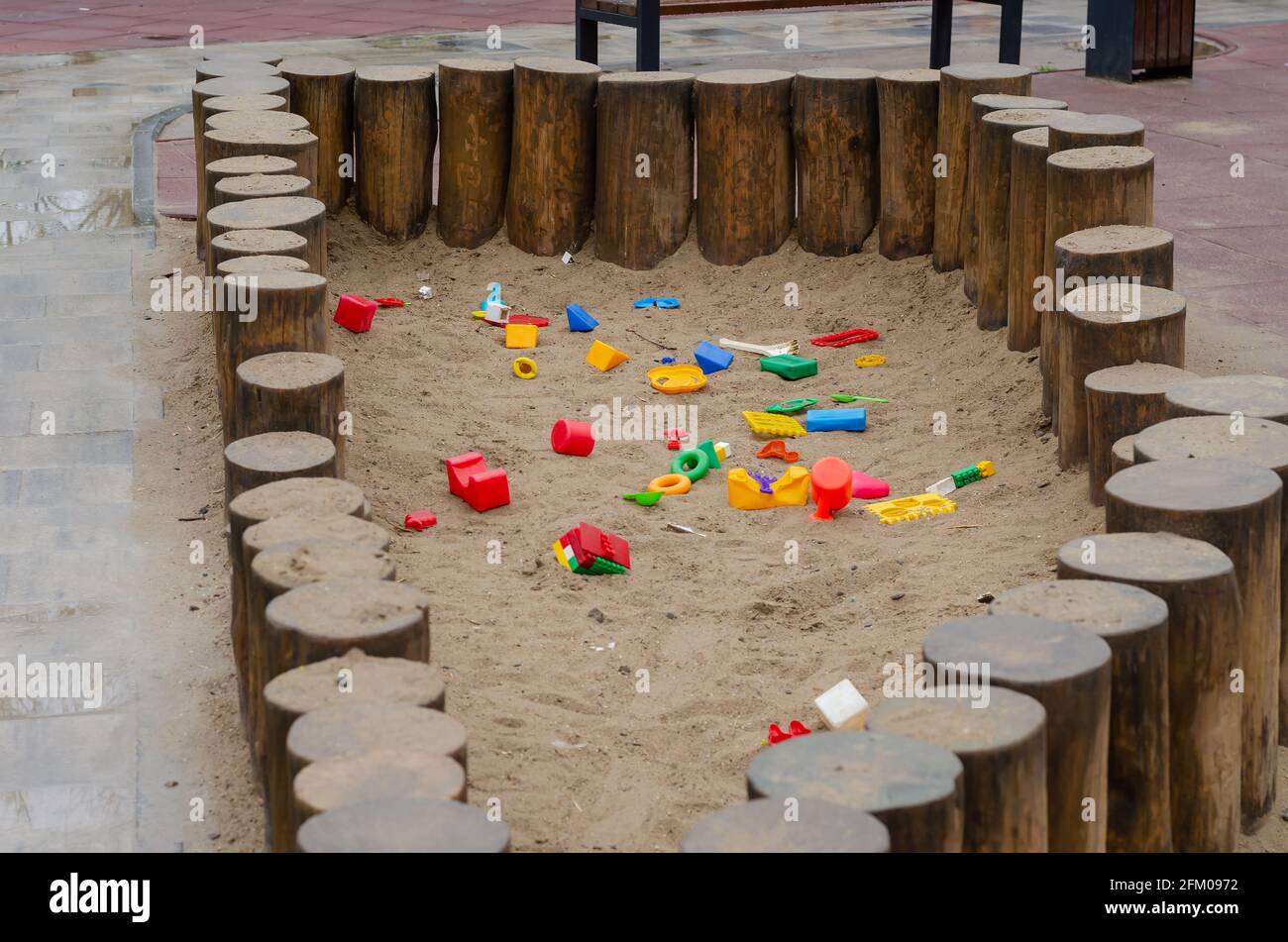 Empty children's sandbox fenced with vertical round logs. Wet sandbox ...