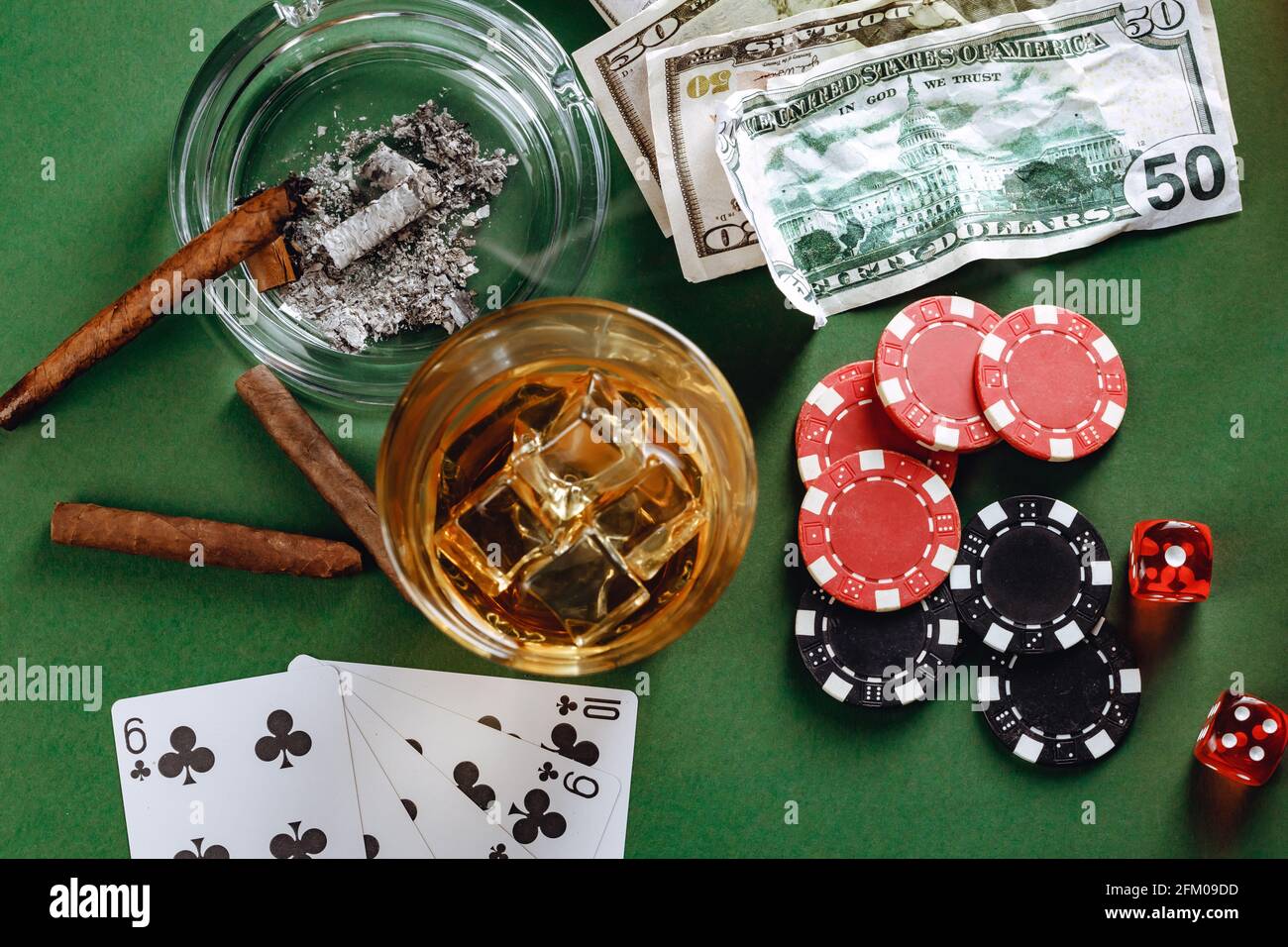 Glass of whiskey, cigar, playing cards and chips on green background ...