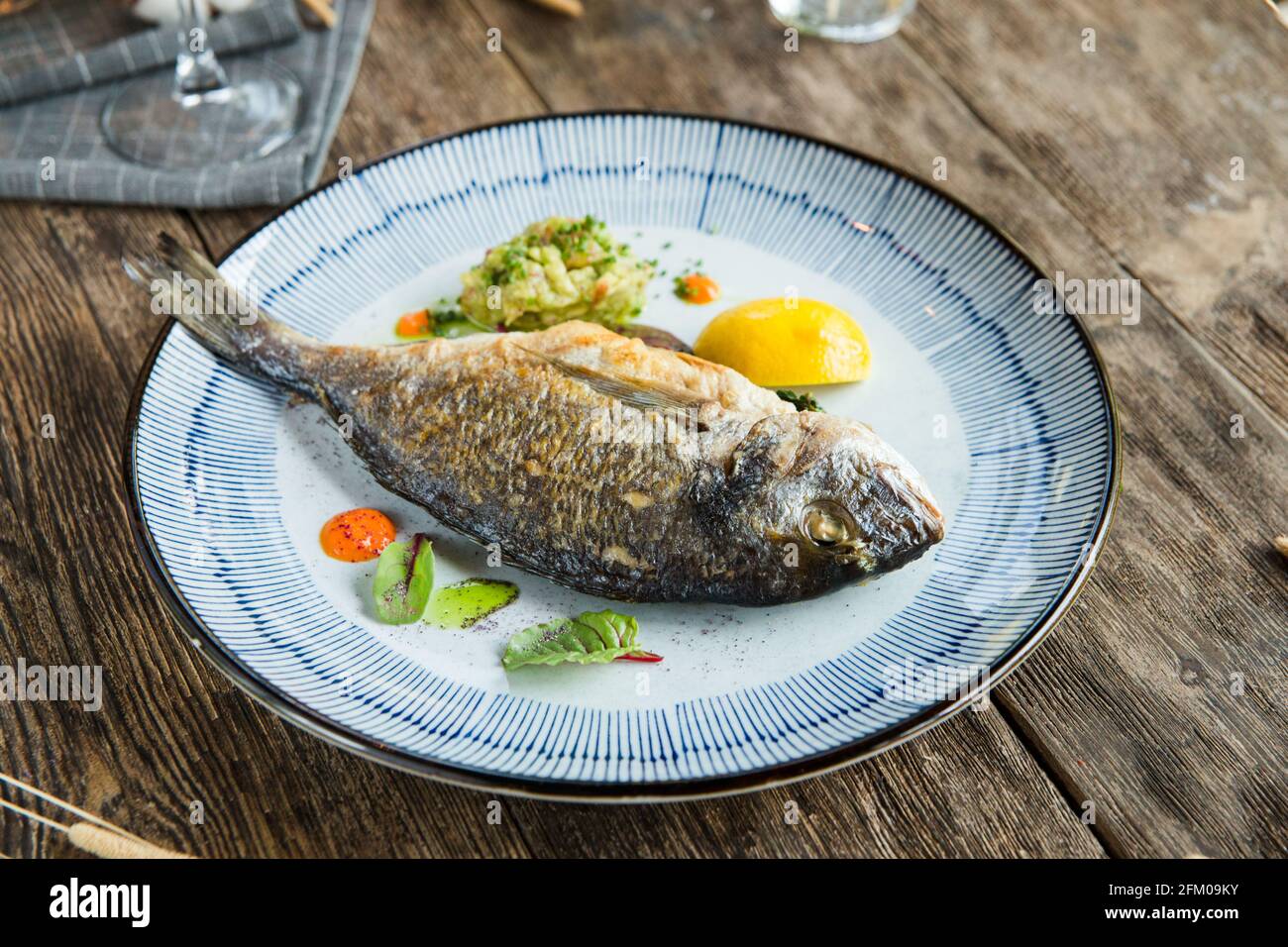 Gourmet roasted dorada fish on a beautiful plate Stock Photo - Alamy