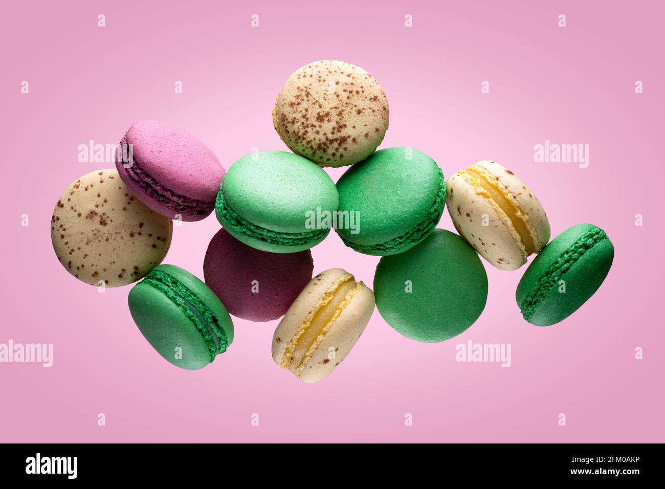 Different types of macaroons in motion falling on pink background Stock ...