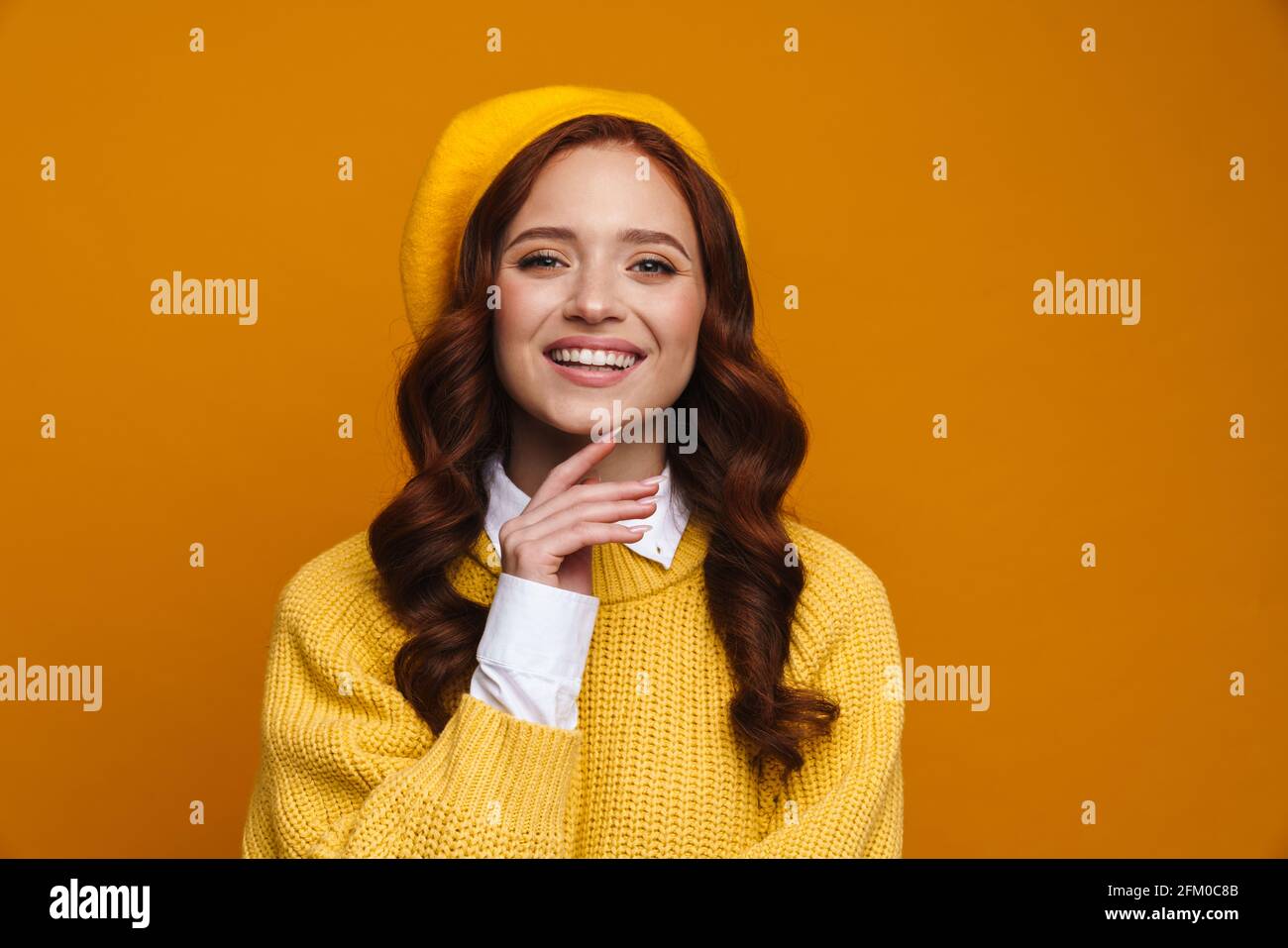 Happy excited young woman with long red hair in sweater and beret ...