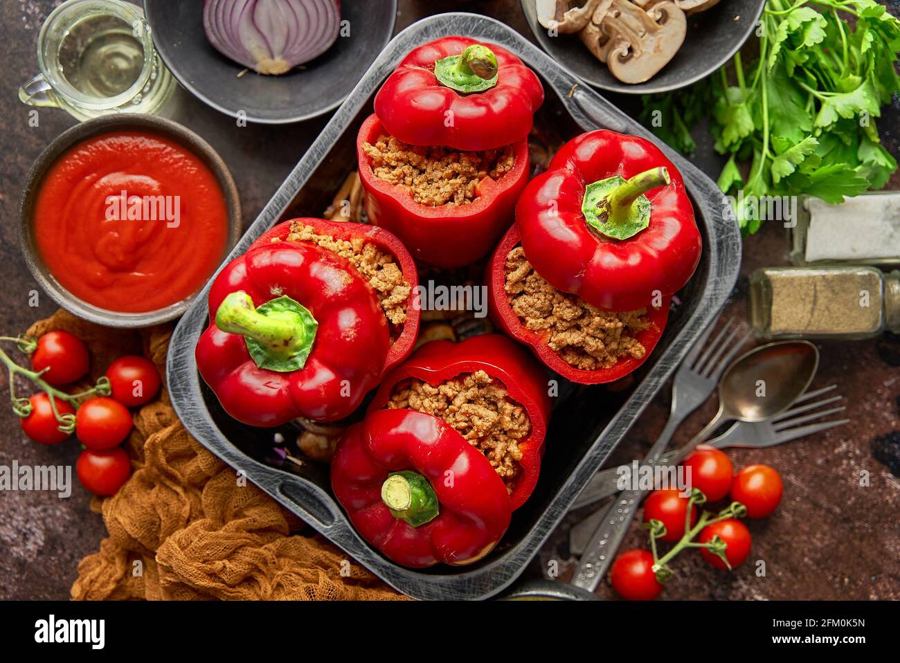Red bell stuffed paprika peppers in iron cooking pot with various ...