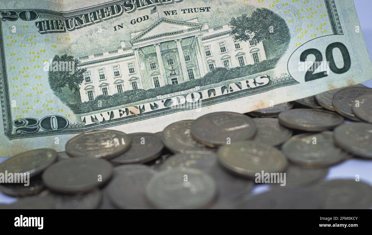 Soft focus of coins and a US twenty dollar bill on white background ...