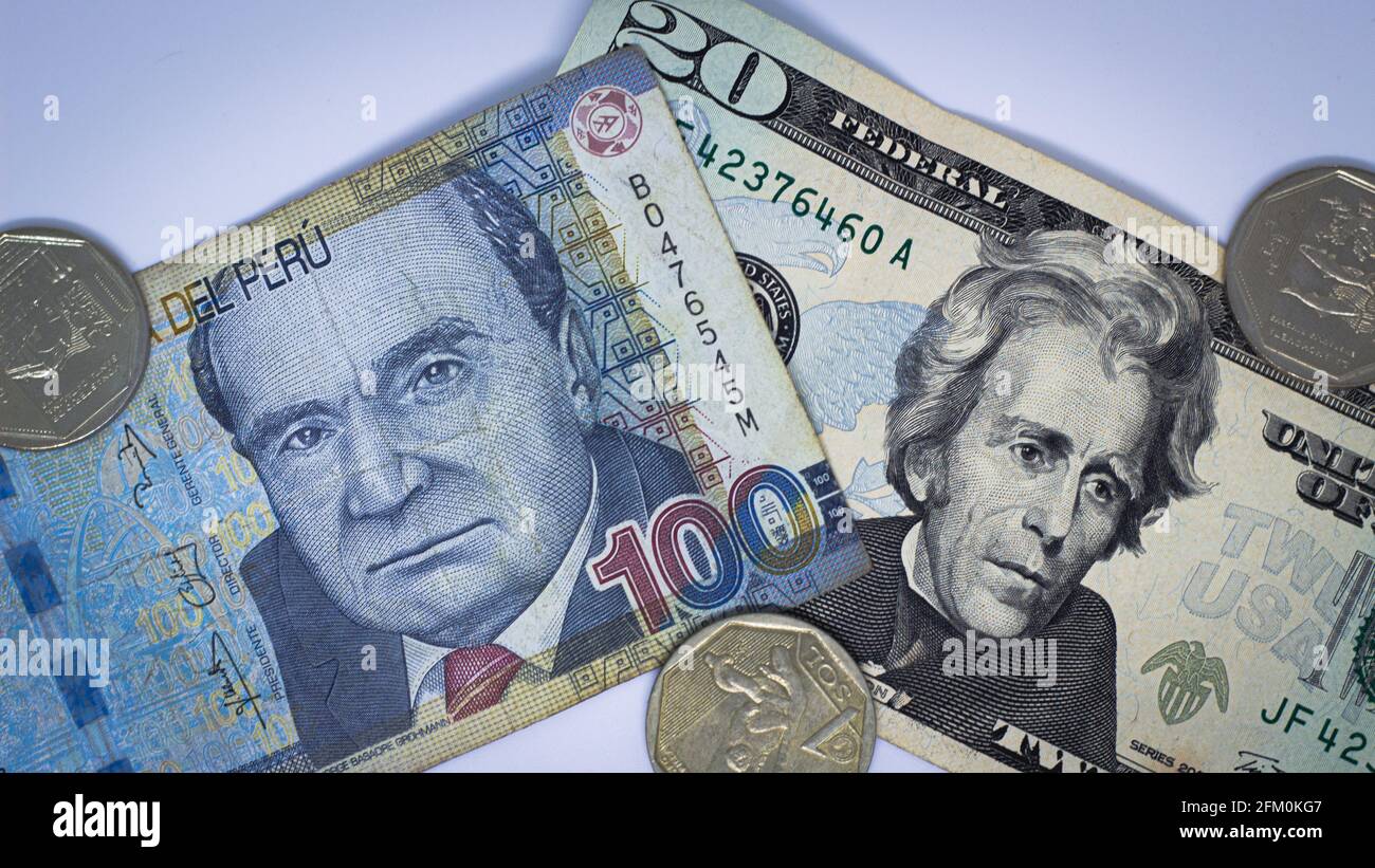 Overhead shot of Peruvian sol and US dollar bills on white background ...