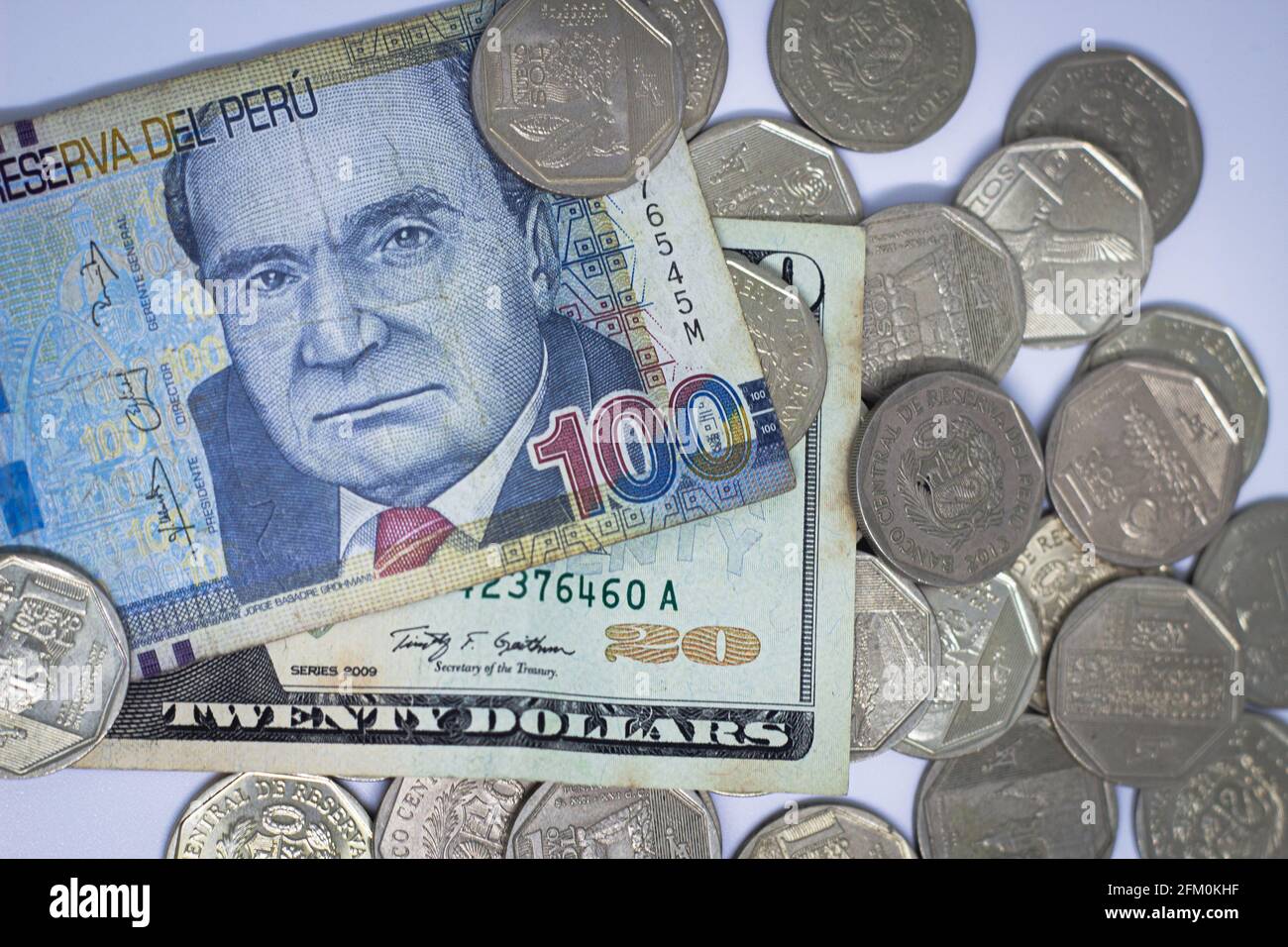 Overhead shot of Peruvian sol and US dollar bills on white background ...