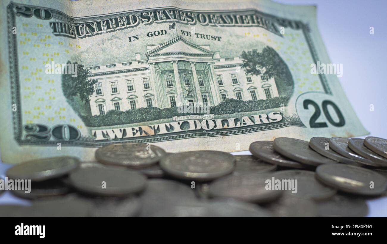 Soft focus of coins and a US twenty dollar bill on white background ...