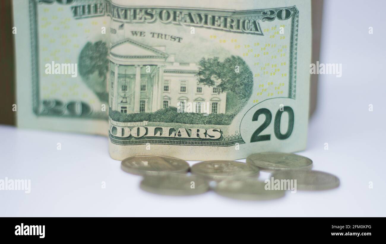 Soft focus of coins and a US twenty dollar bill on white background ...