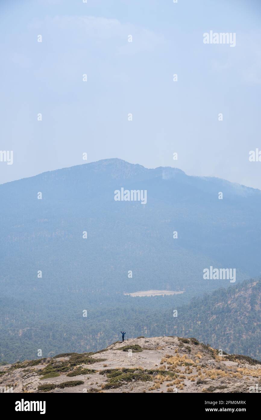 Vertical shot of a Hispanic hiker on top of mount Tlaloc in Mexico ...
