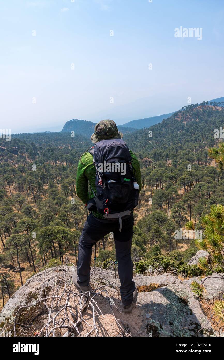 Vertical shot of a Hispanic hiker on top of mount Tlaloc in Mexico ...