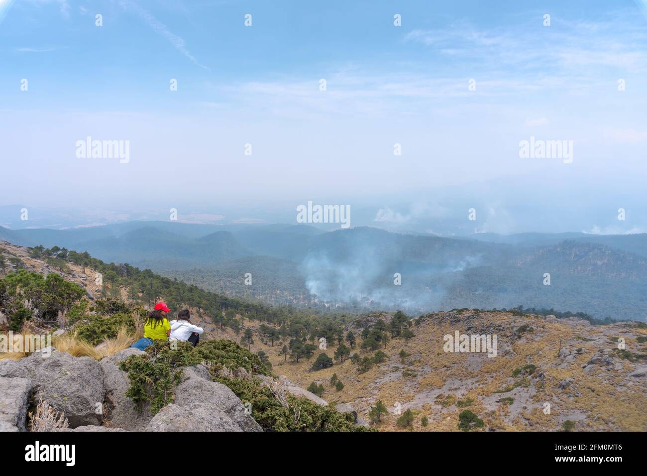Closeup shot of hikers sitting on top of the Tlaloc Mount on a gloomy ...