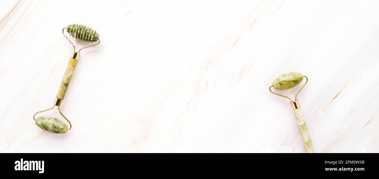 SPA concept. Two green face rollers from natural jade stone on a light ...