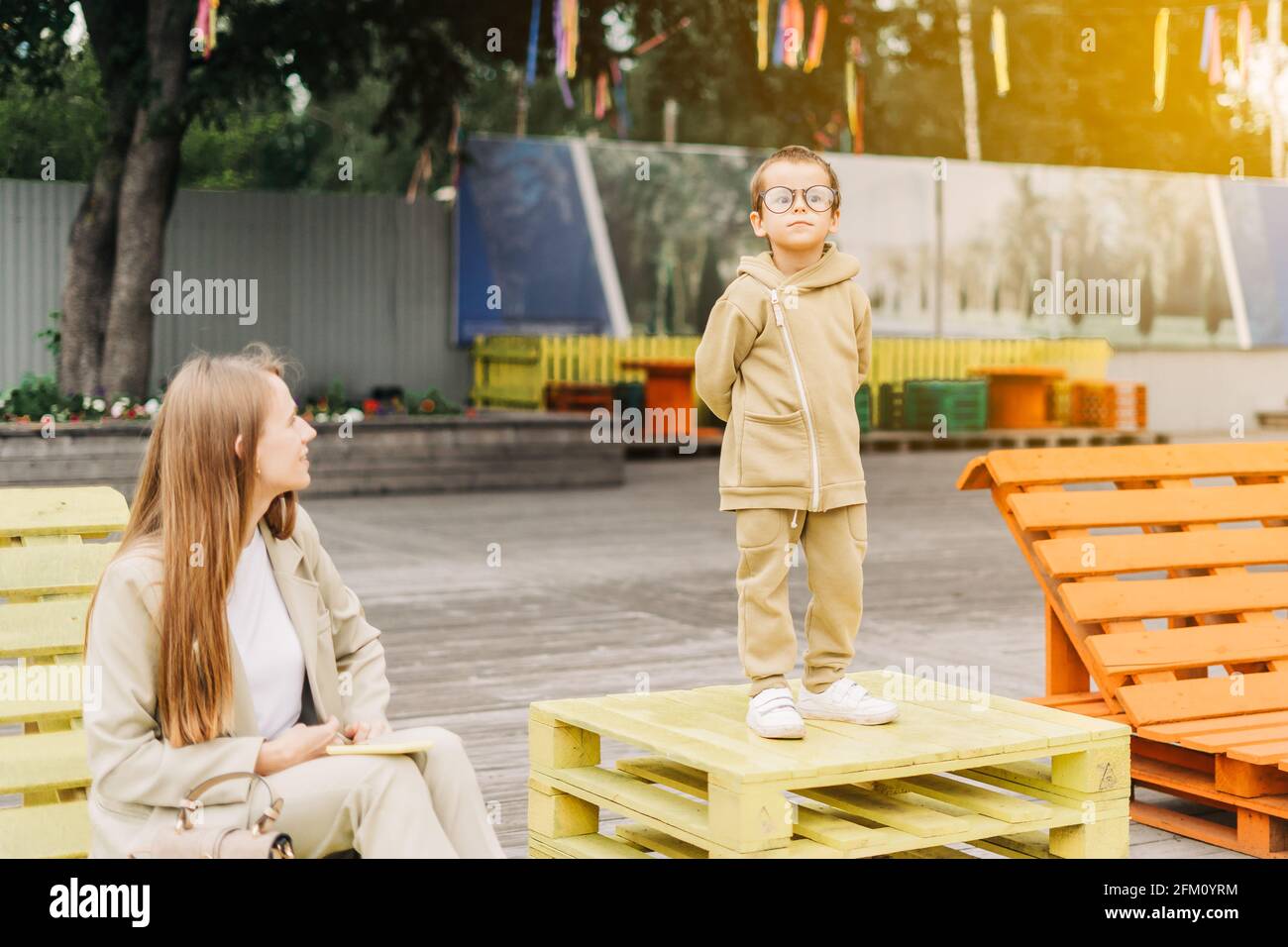Funny and surprised young mom with preschooler son sit on bench Stock ...