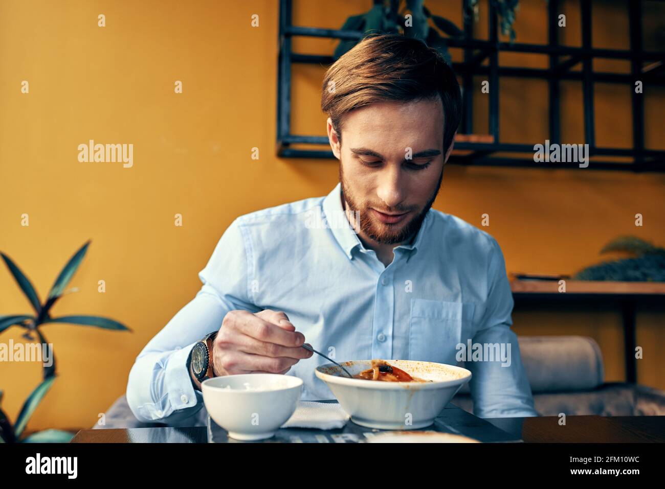 Attractive man eating salad sitting hi-res stock photography and images ...