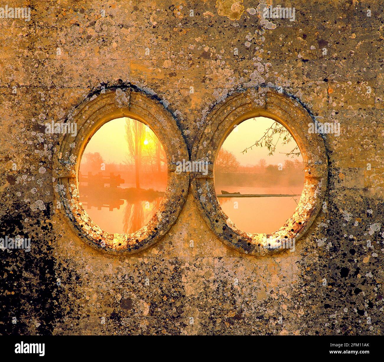 Dawn at weir, through stone wall peep holes Stock Photo - Alamy