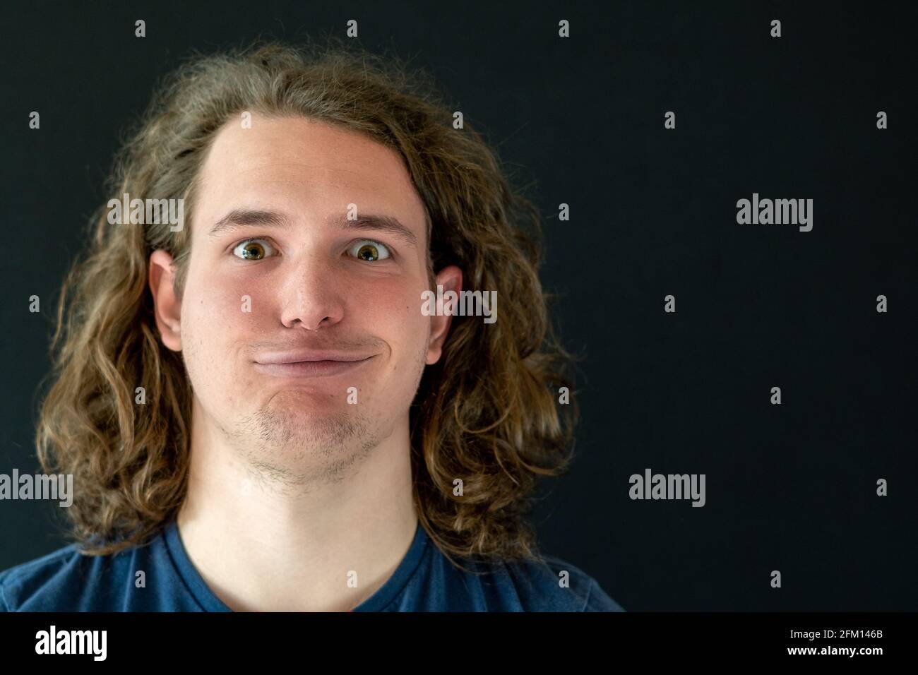 Portrait of a Middle Eastern man with long curly hair and a big smirk ...