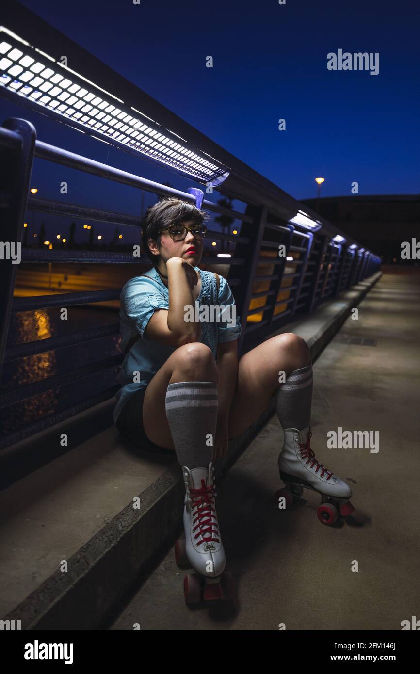 Female sitting on a bench and about to put the roller-skates on Stock ...