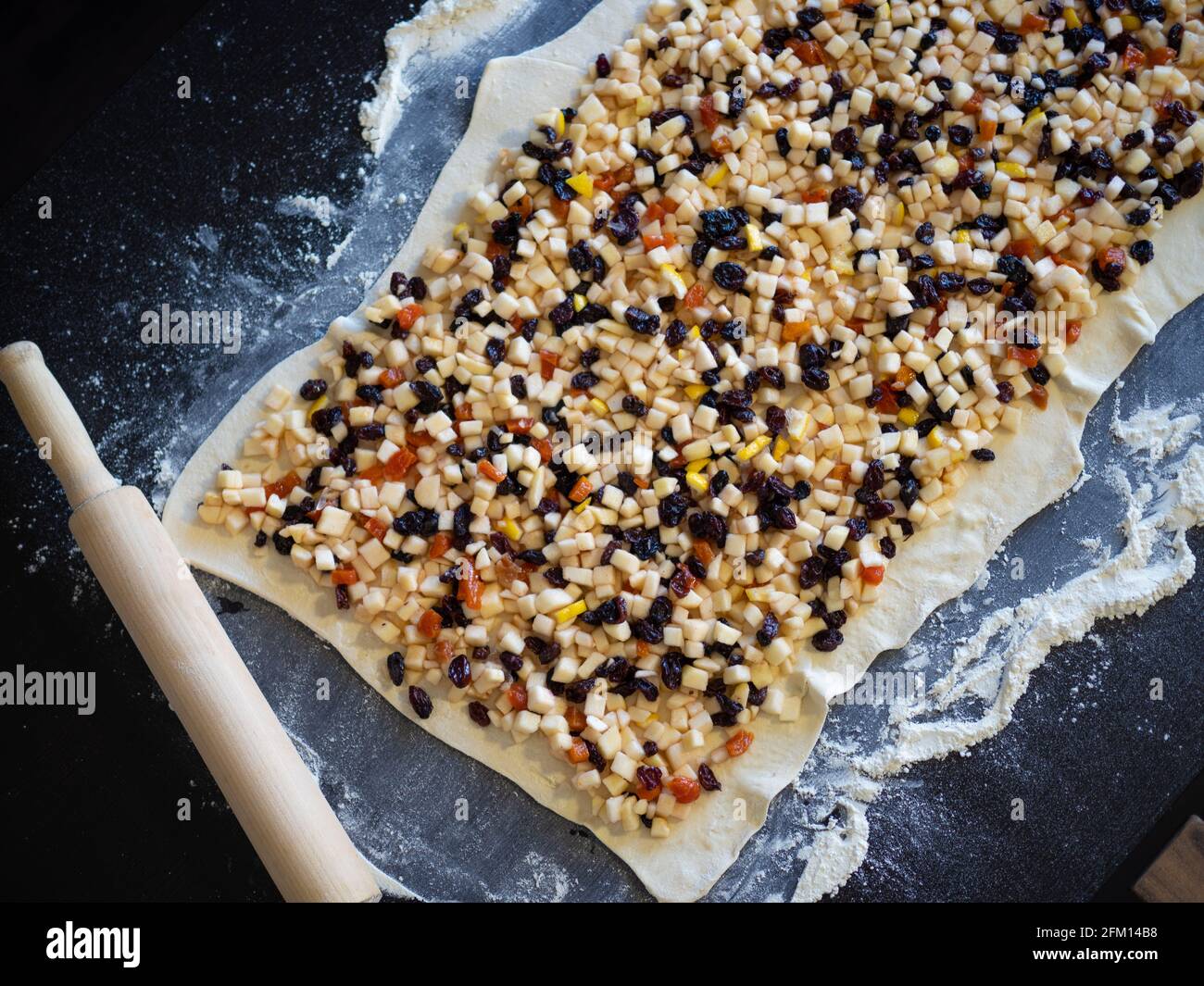 Process of making apple strudel, a layer of dough with the filling laid ...
