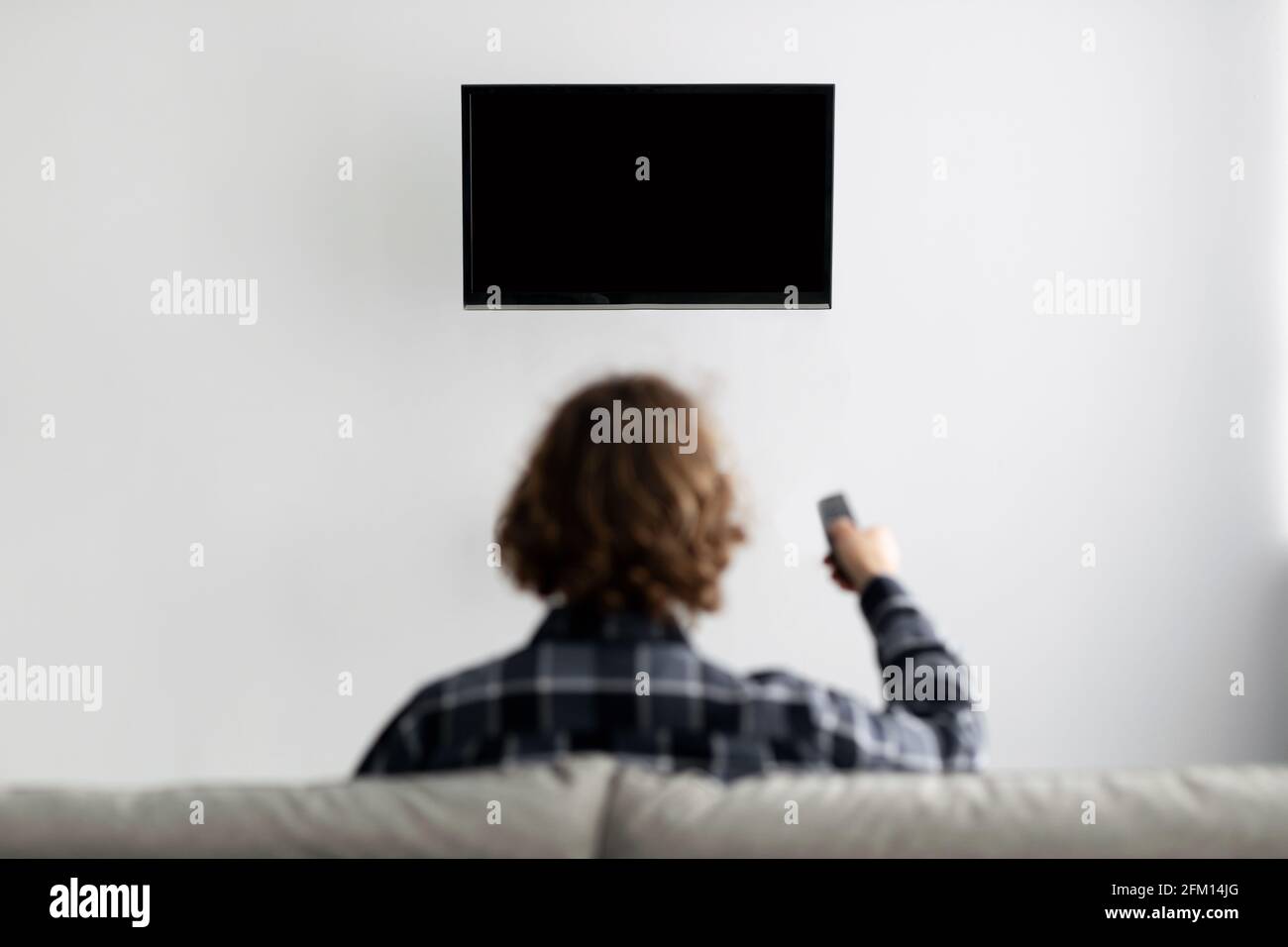 Rear View Of Guy Watching TV Switching Channels At Home Stock Photo - Alamy