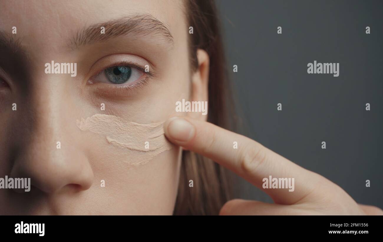 Young girl puts a foundation cream on her face Stock Photo - Alamy