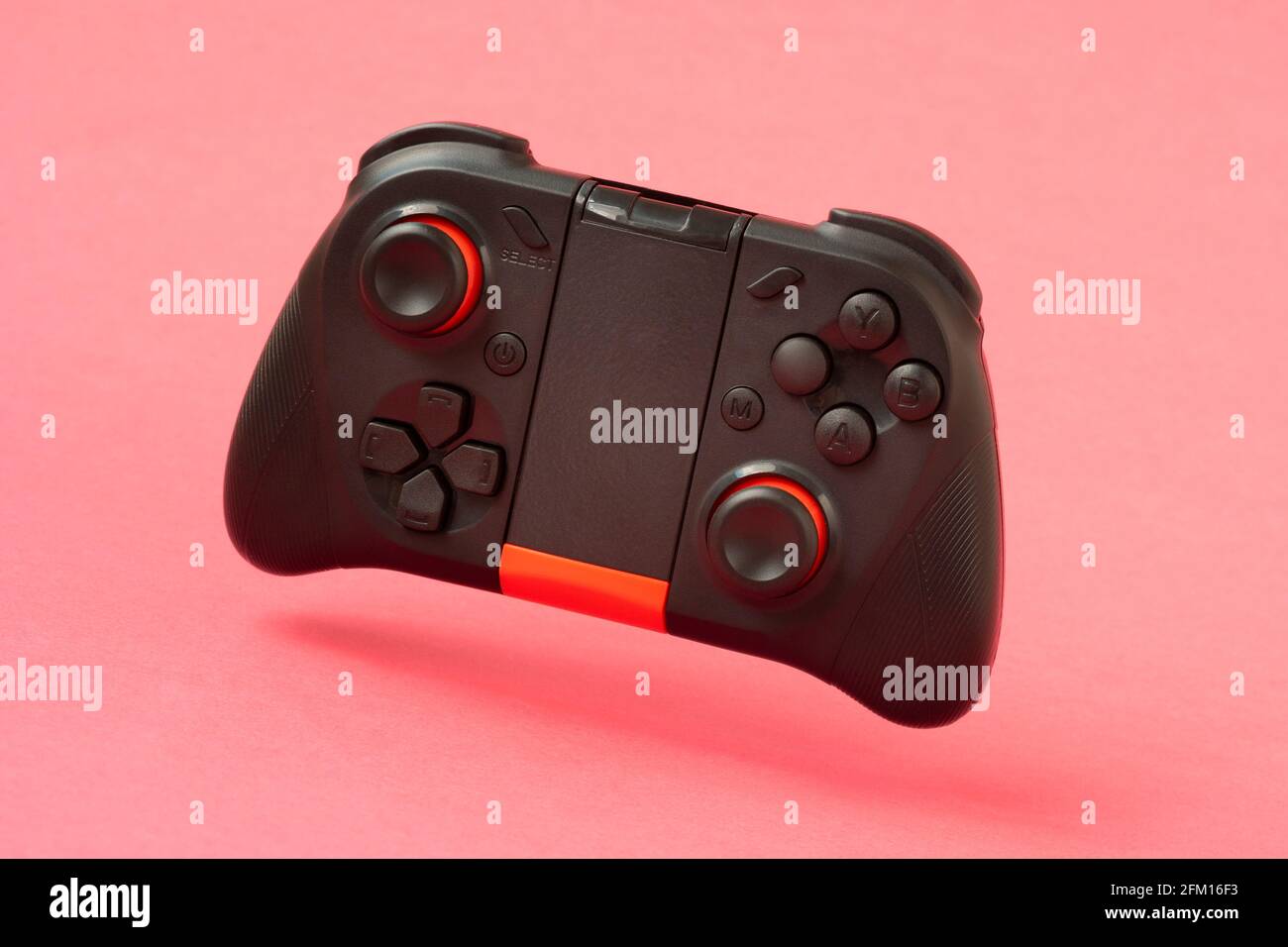 Video game controller falling on the pink background Stock Photo - Alamy