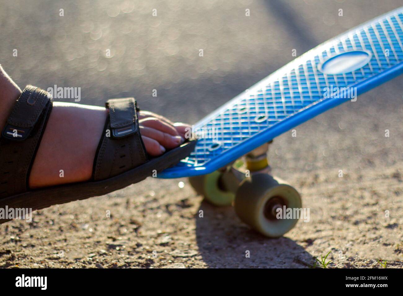 Defocus close-up little boy doing tricks on a penny skateboard. Young ...
