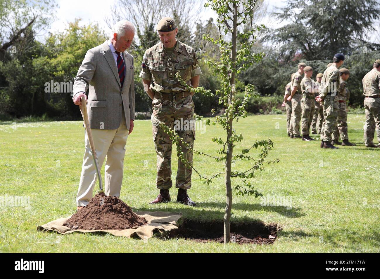 The Prince of Wales, Colonel Welsh Guards, helps plant a tree next to ...